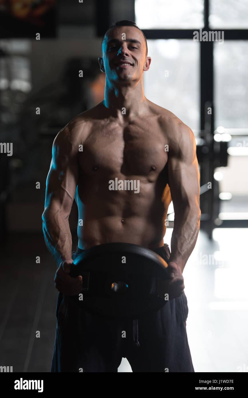 Muscular Man Exercising Abdominal Muscles With Weights In A Modern ...
