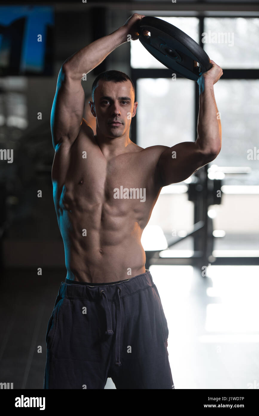 Muscular Man Exercising Abdominal Muscles With Weights In A Modern ...