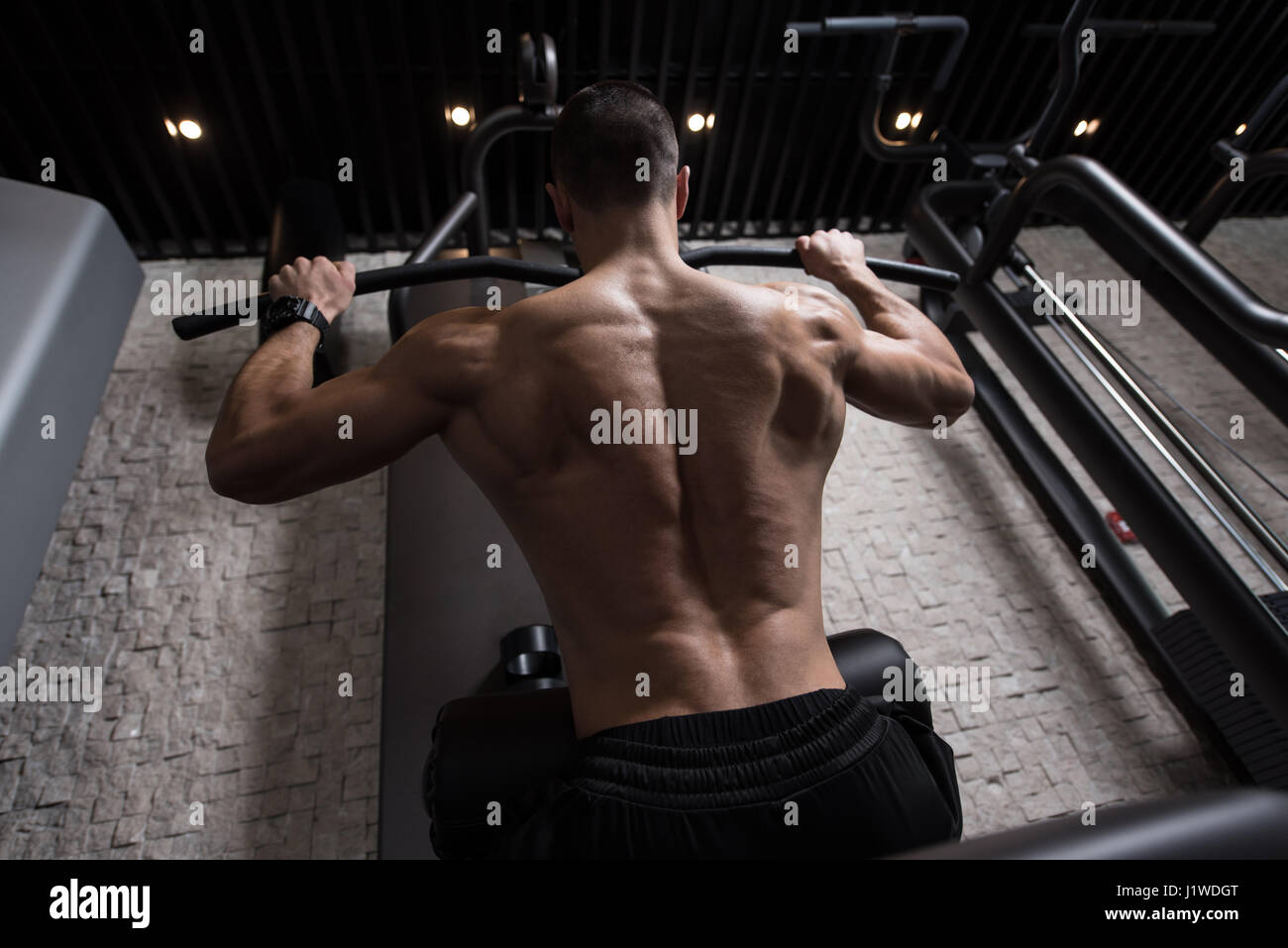 Handsome Bodybuilder Doing Heavy Weight Exercise For Back On Machine ...