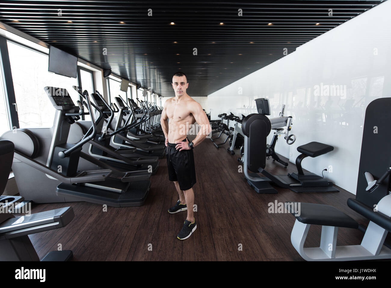 Healthy Man Standing Strong In The Gym And Flexing Muscles - Muscular ...