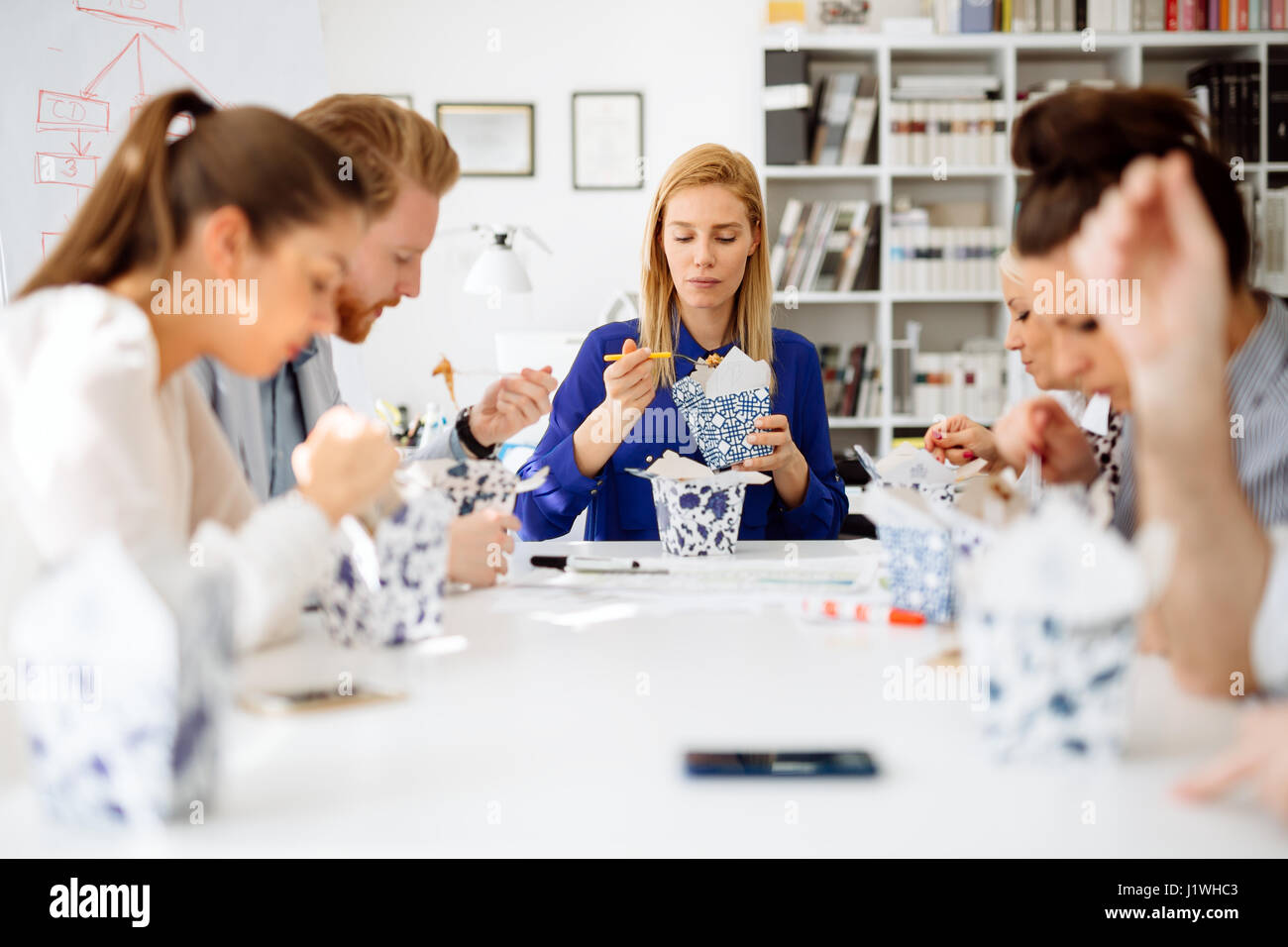 Business people eating meals in office Stock Photo - Alamy