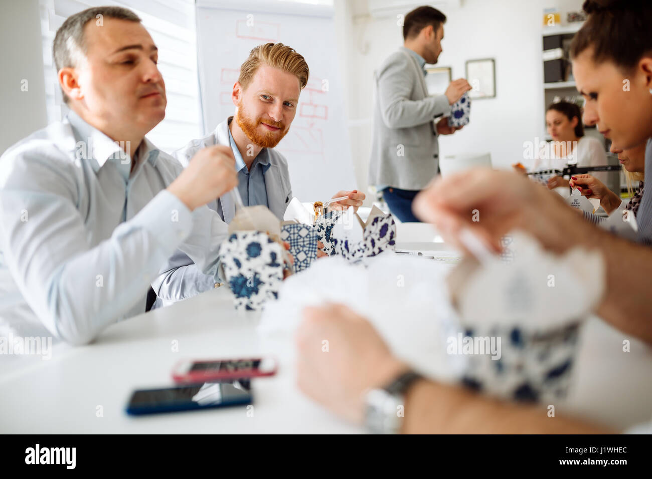 Colleagues eating in office during lunch break Stock Photo - Alamy