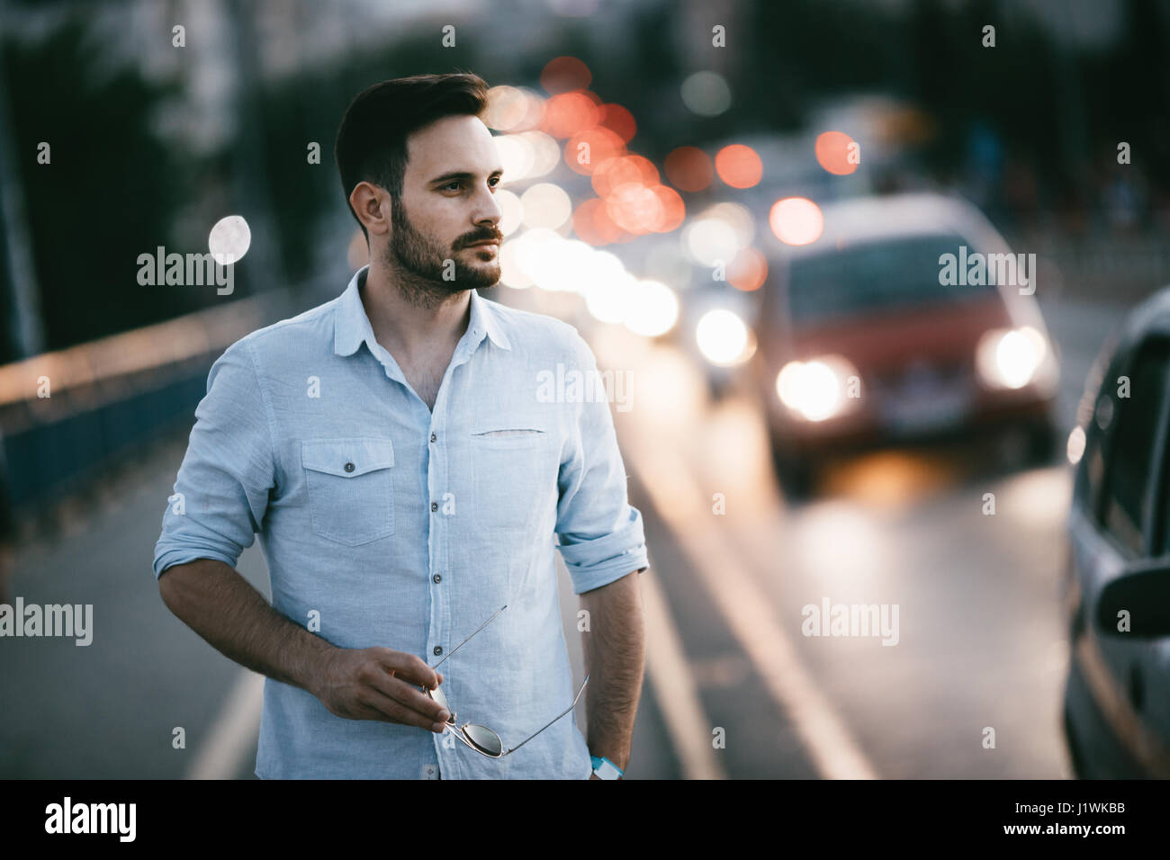 Handsome man walking home at night alone in city Stock Photo - Alamy