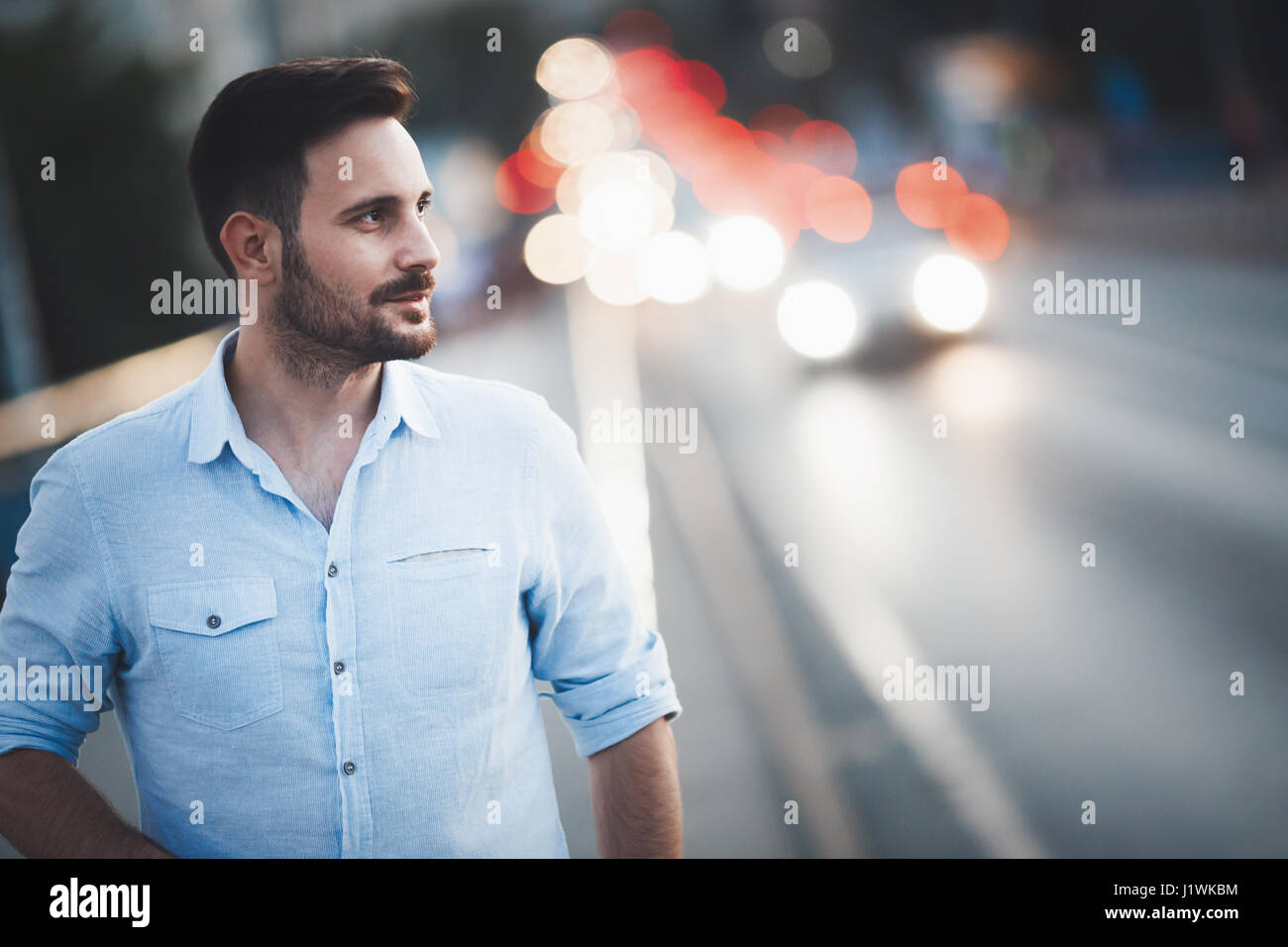 Handsome man walking home at night alone in city Stock Photo - Alamy