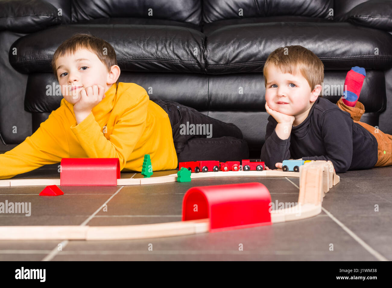 Children playing with wooden toy train. Brothers build wooden railroad ...