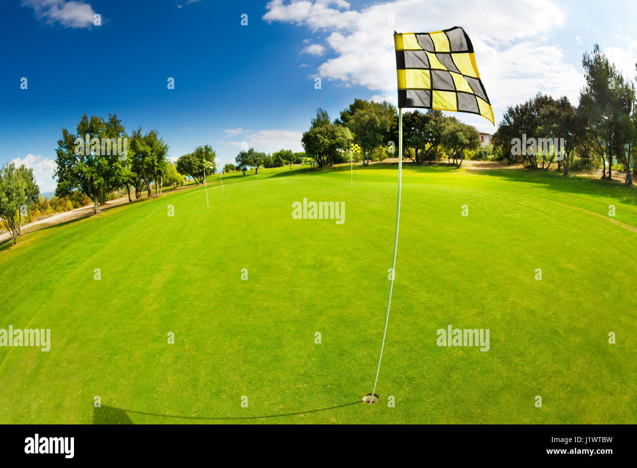 Close-up picture of pin waving in the breeze and cup at the putting ...