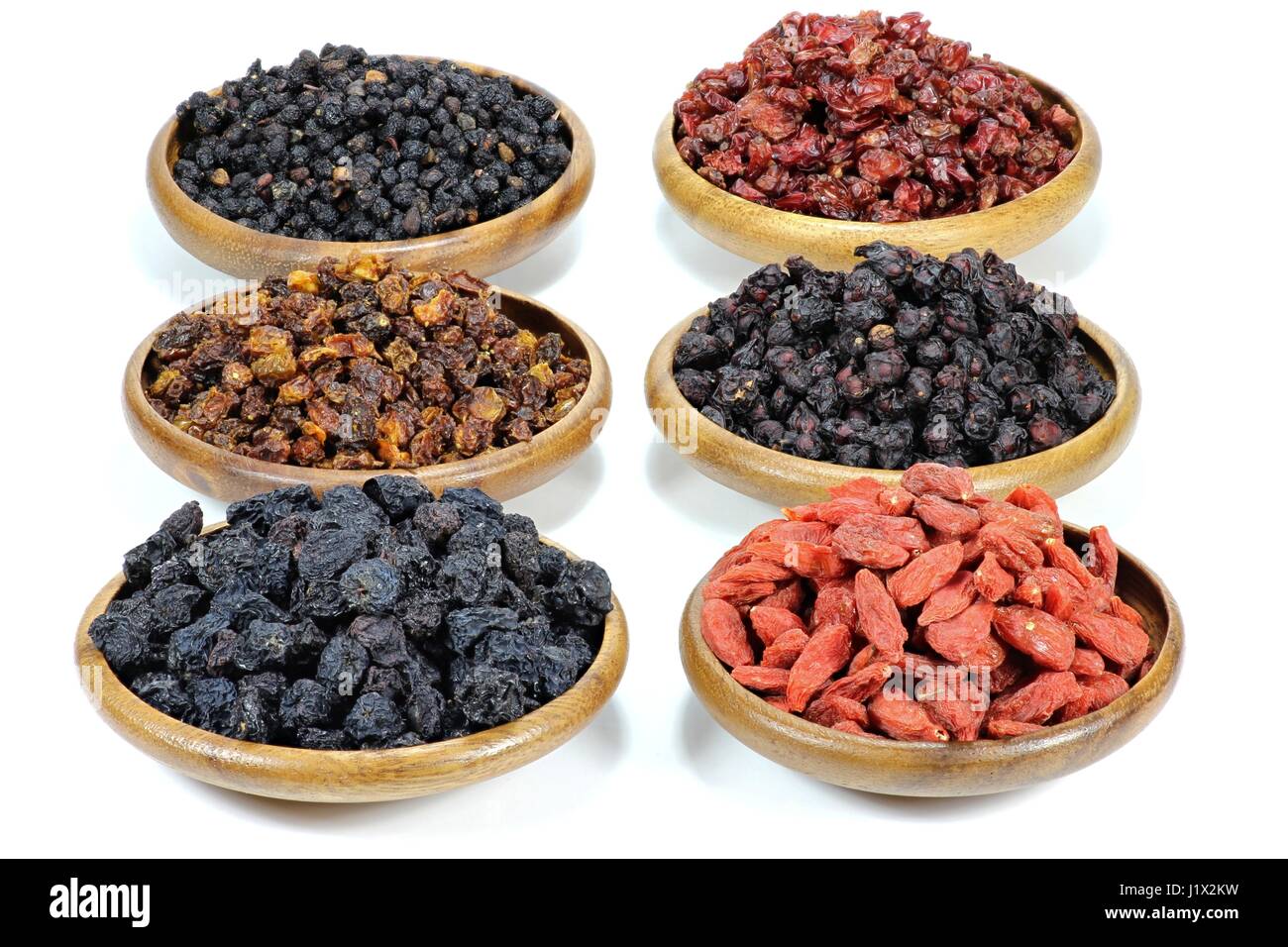 assortment of dried berries in wooden bowls isolated on white ...