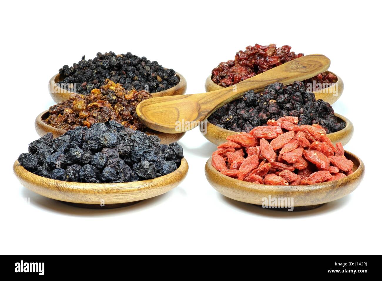 assortment of dried berries in wooden bowls isolated on white ...