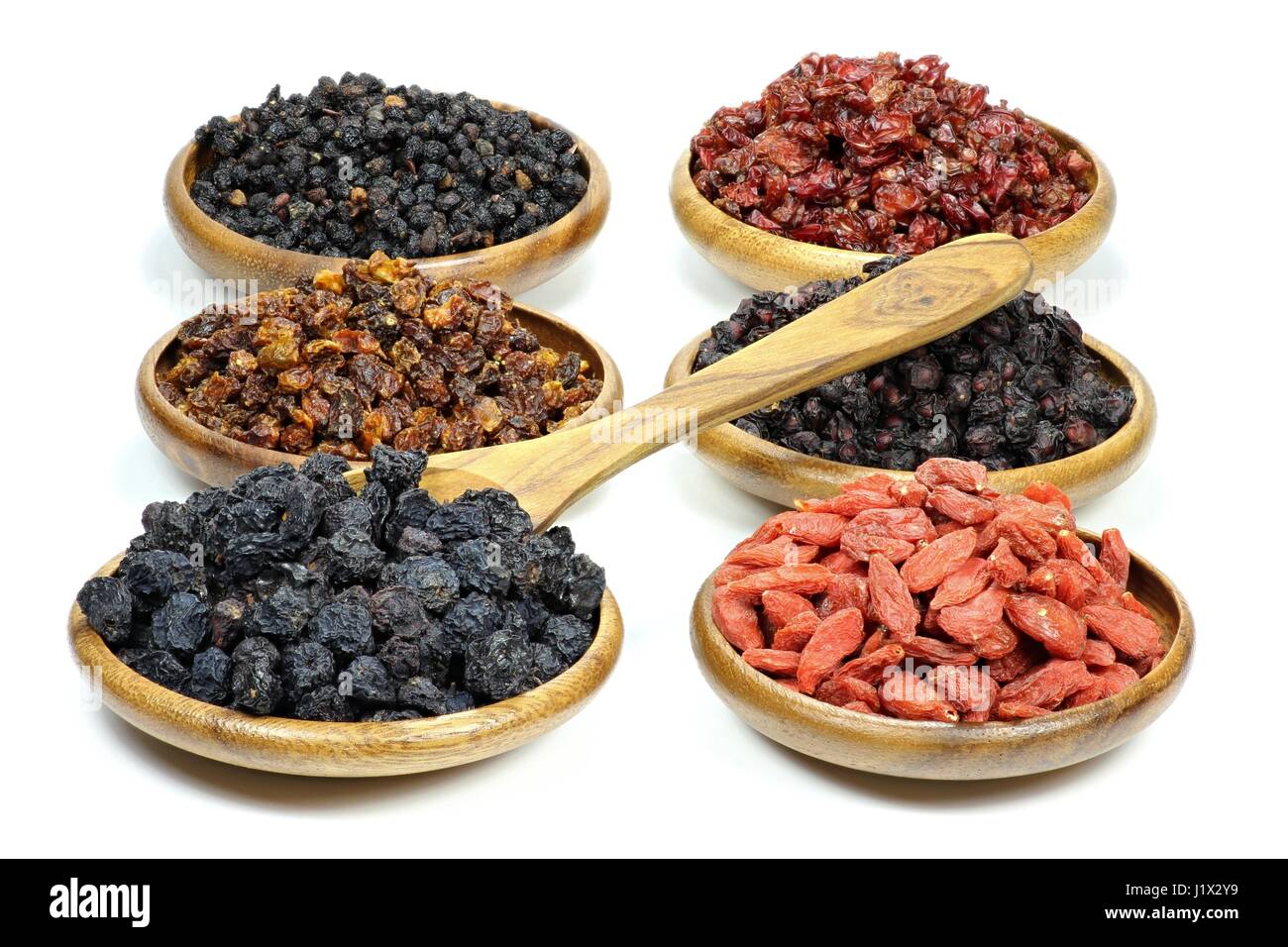 assortment of dried berries in wooden bowls isolated on white ...