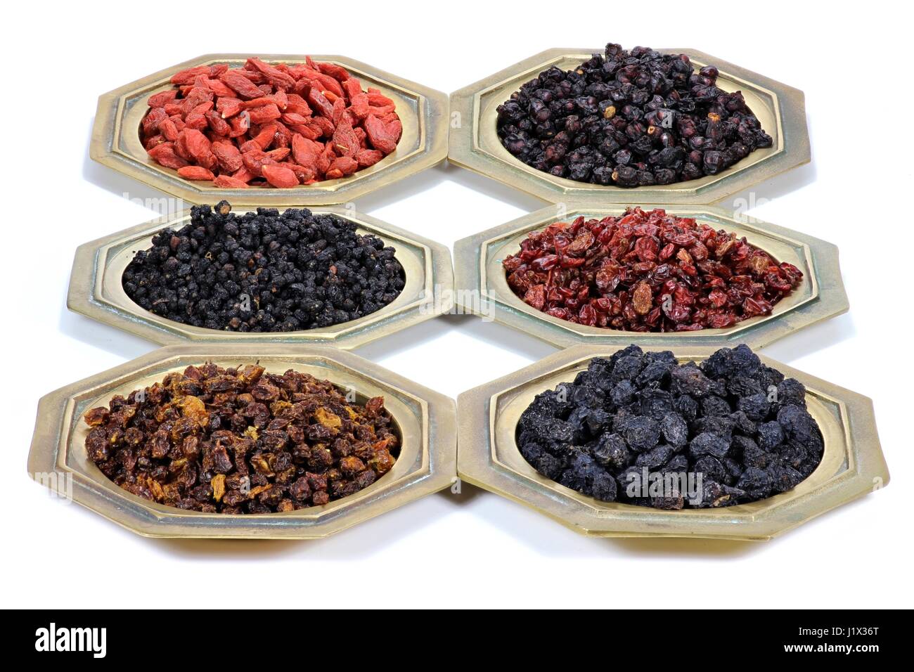 assortment of dried berries in brass bowls isolated on white background ...