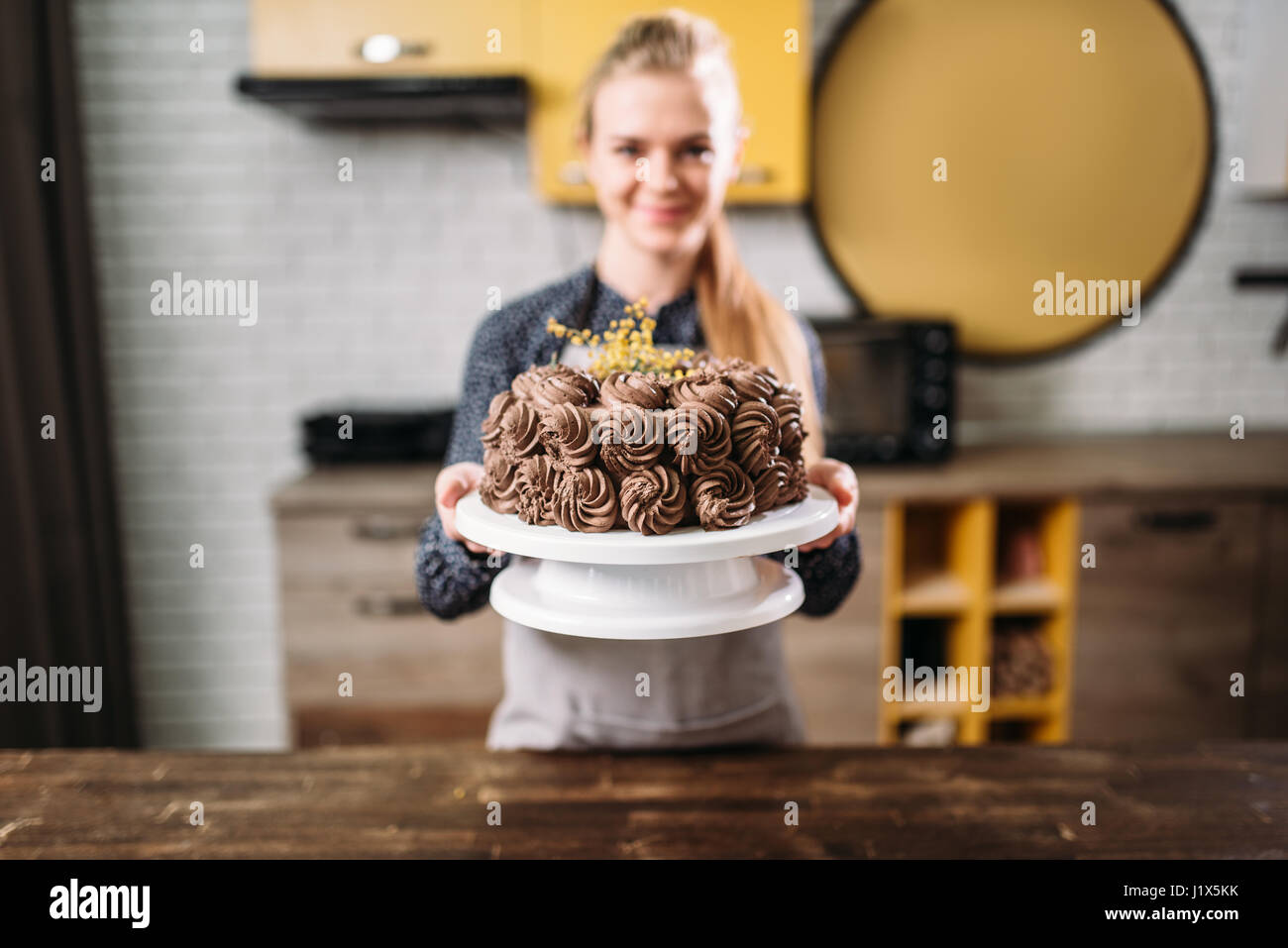 Woman cook shows chocolate cake, culinary masterpiece. Kitchen on ...