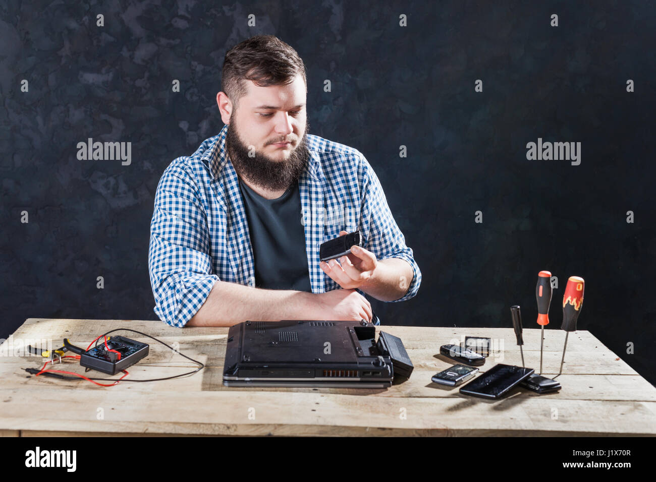 Male computer engineer fixing problem with laptop. Electronic devices ...