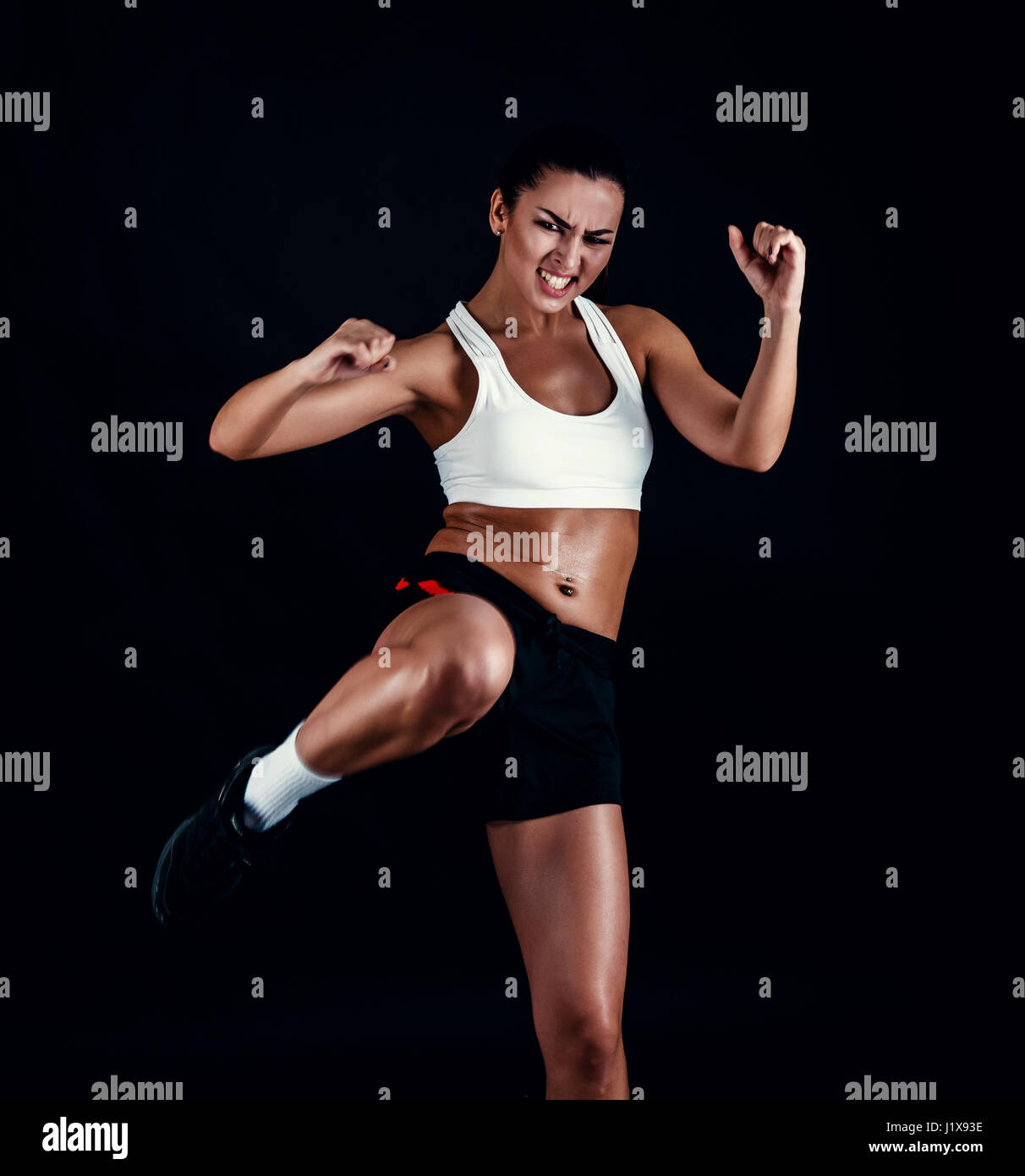 Angry fitness girl ready for fight on black background Stock Photo - Alamy