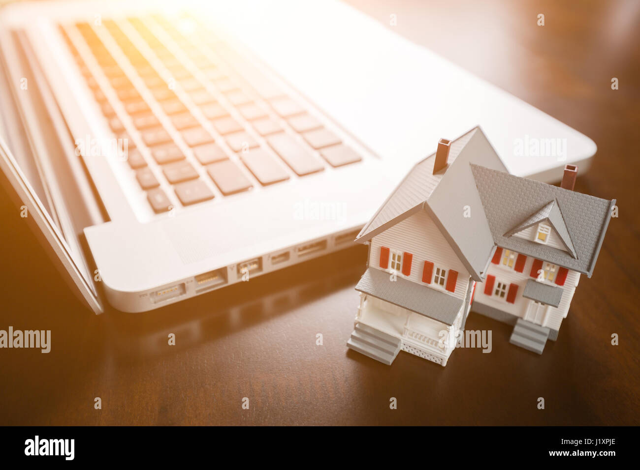 Miniature House And Laptop Computer Resting on Desktop Stock Photo - Alamy