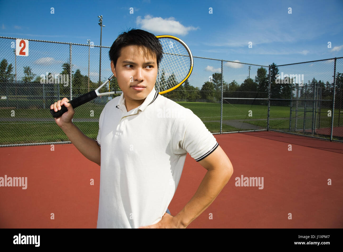 A young sporty asian man playing tennis Stock Photo - Alamy