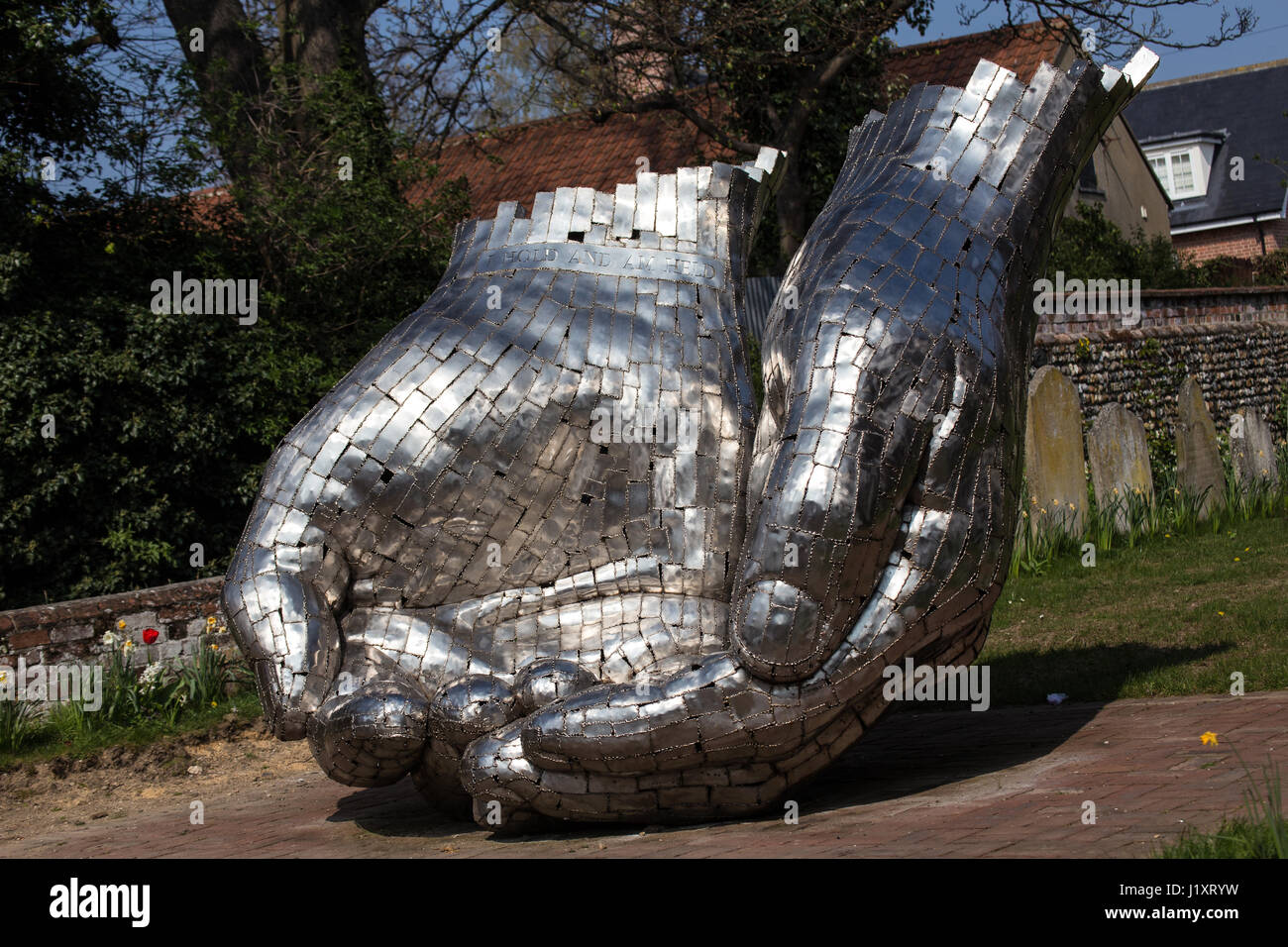 A metal sculpture of two hands outside Woodbridge Quay Church in ...