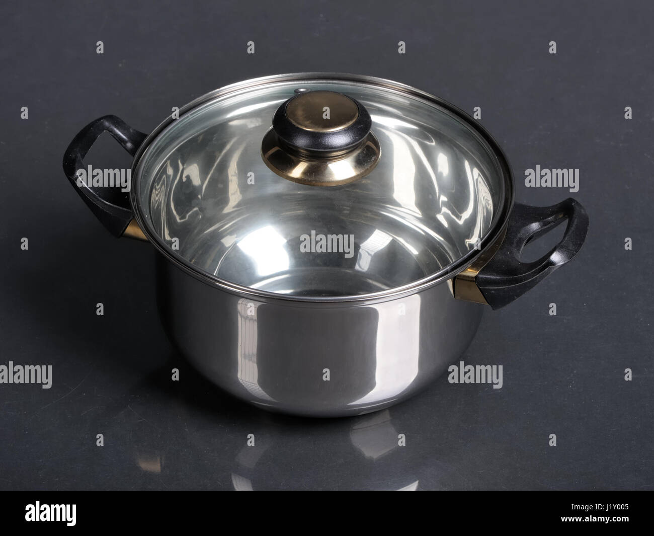 Metallic pan on black background Stock Photo - Alamy