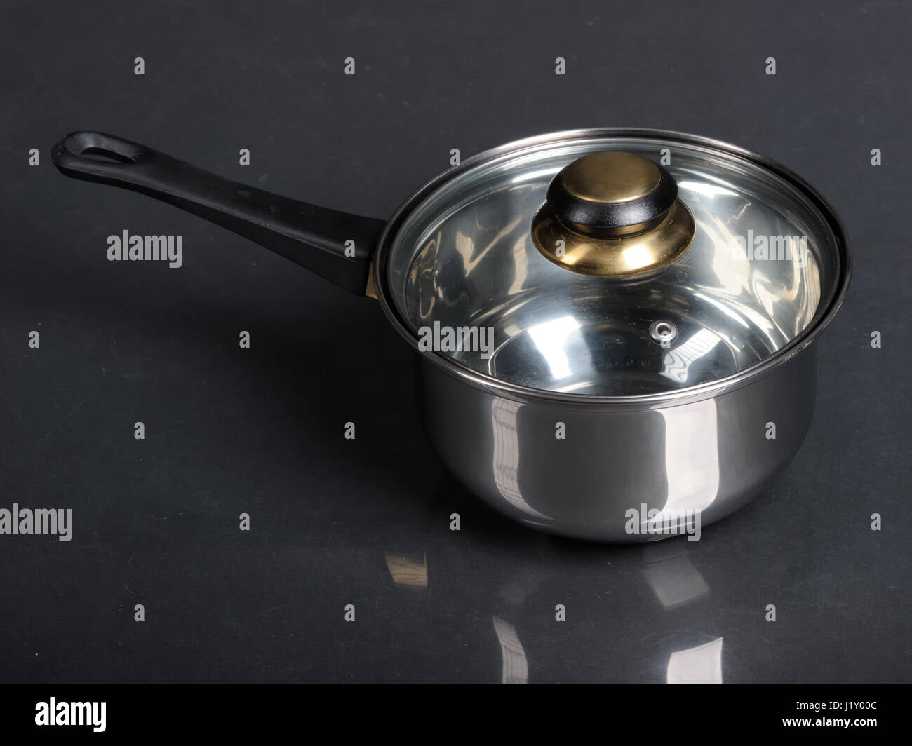 Metallic pan on black background Stock Photo - Alamy