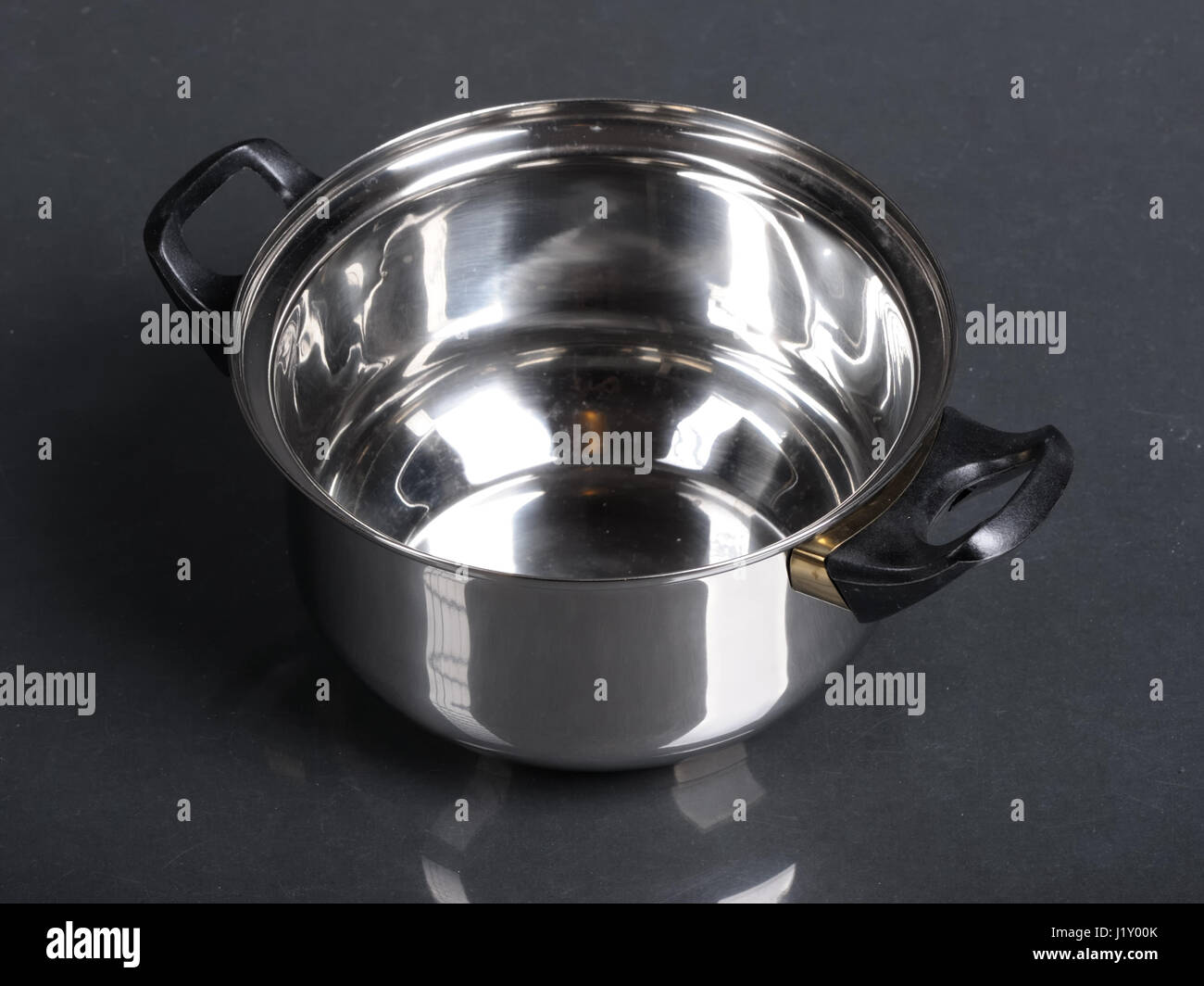 Metallic pan on black background Stock Photo - Alamy