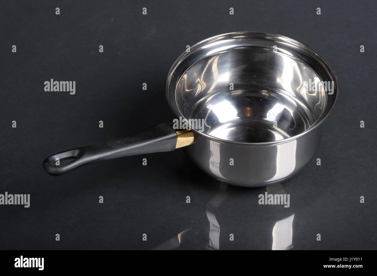 Metallic pan on black background Stock Photo - Alamy