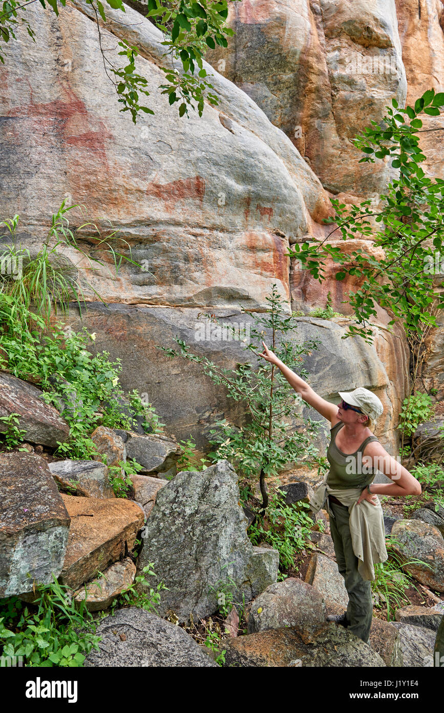 tourist looks on Rock art, ancient San paintings, Tsodilo Hills ...