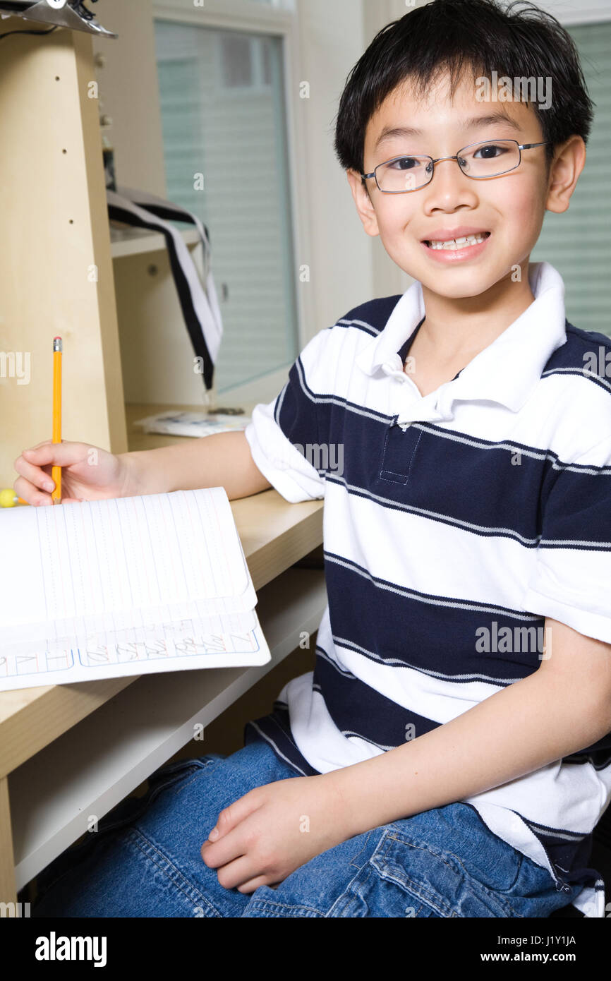 A shot of an asian kid studying at home Stock Photo - Alamy