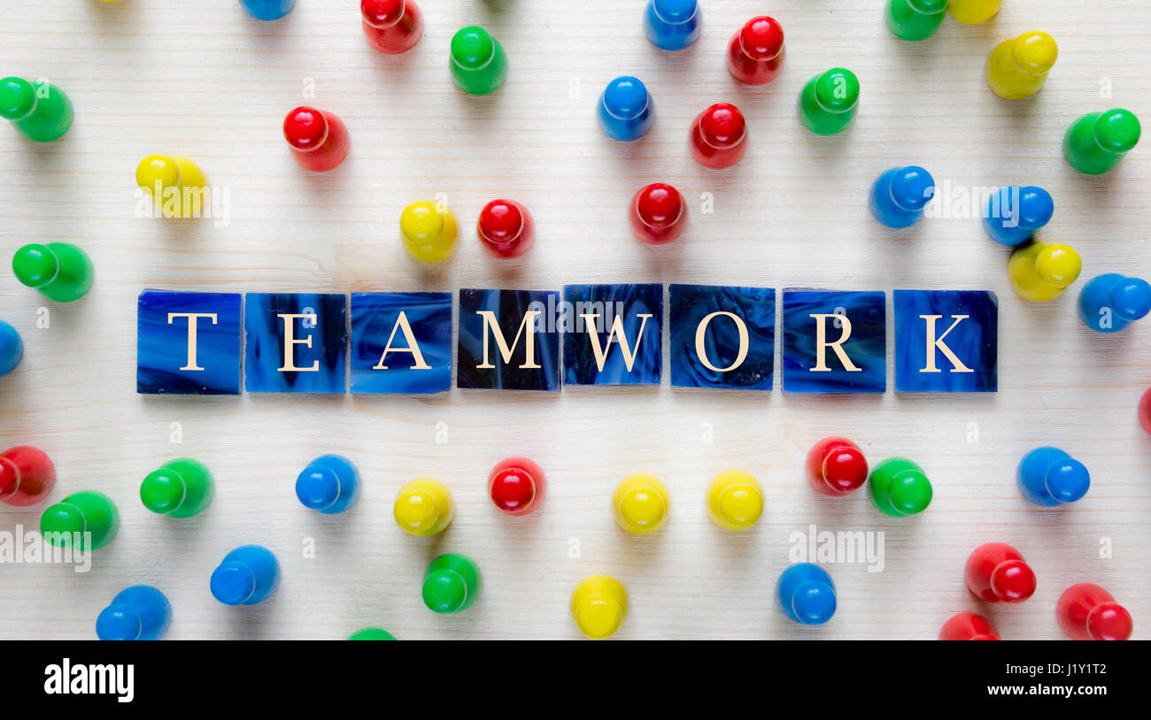 Mosaic tiles with letters and board game pieces - Concept of teamwork ...