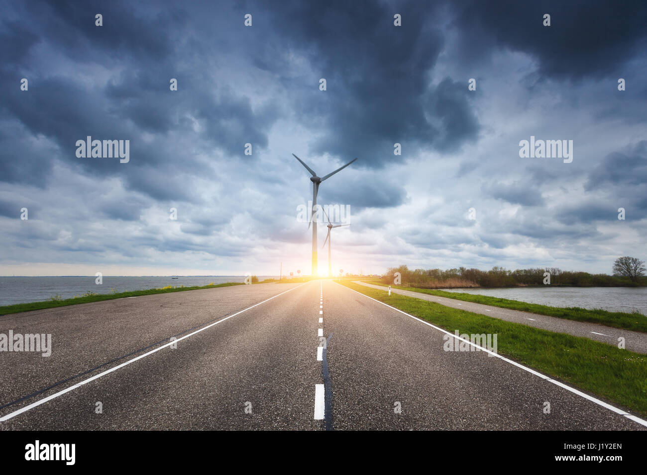 Beautiful asphalt road with wind turbines generating electricity at ...