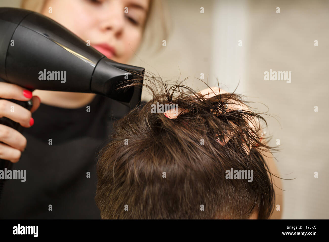 Professional hairdresser doing haircut men's hair. Drying hair with a ...