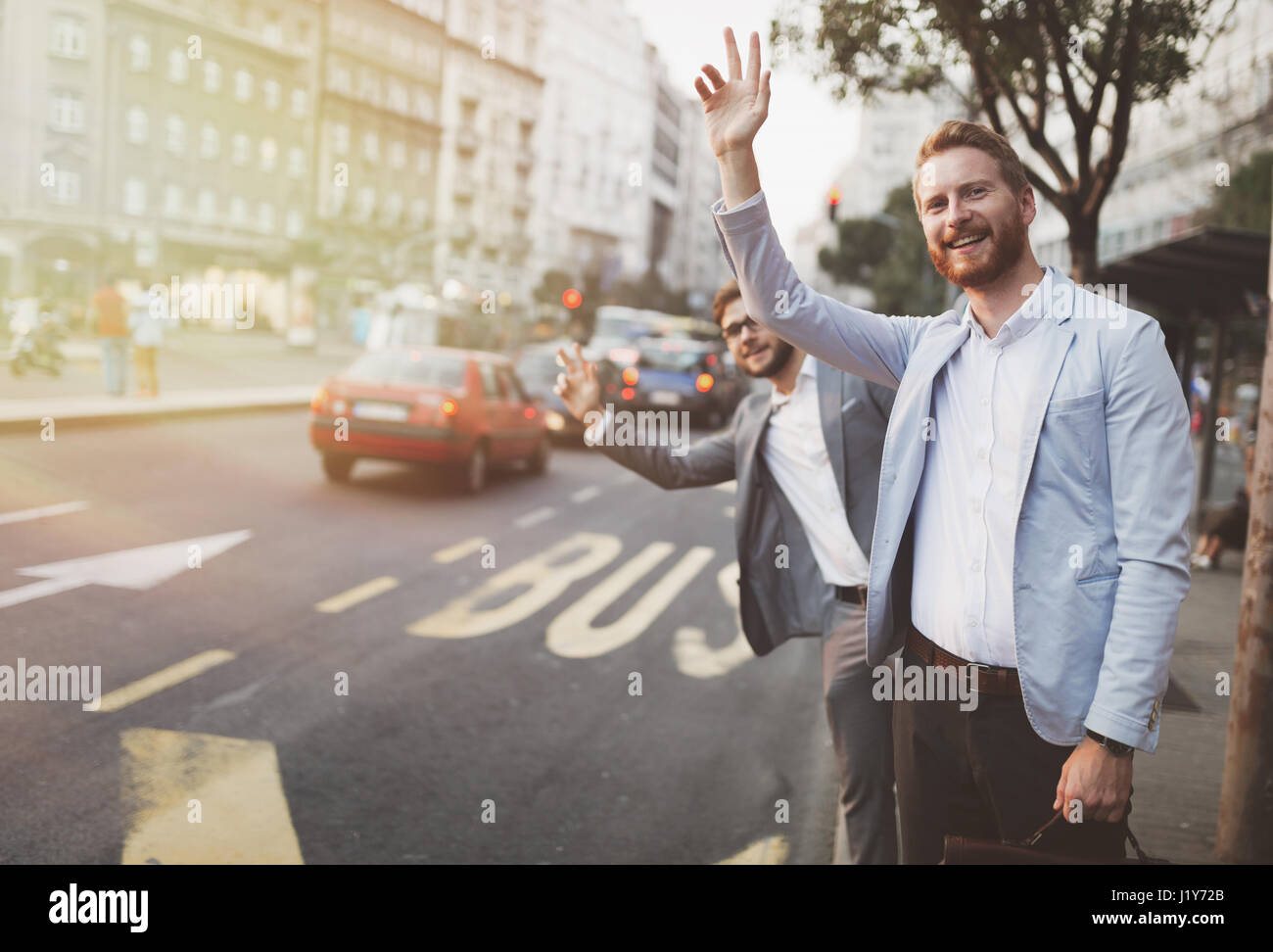 Businessman waving for a taxi in busy city Stock Photo - Alamy