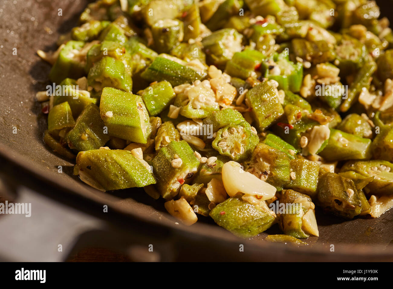 cut okra and garlic pan fried in olive oil Stock Photo - Alamy