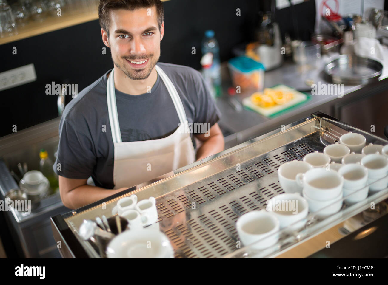 Portrait of a barista leaning on the coffee machine at the coffee shop ...