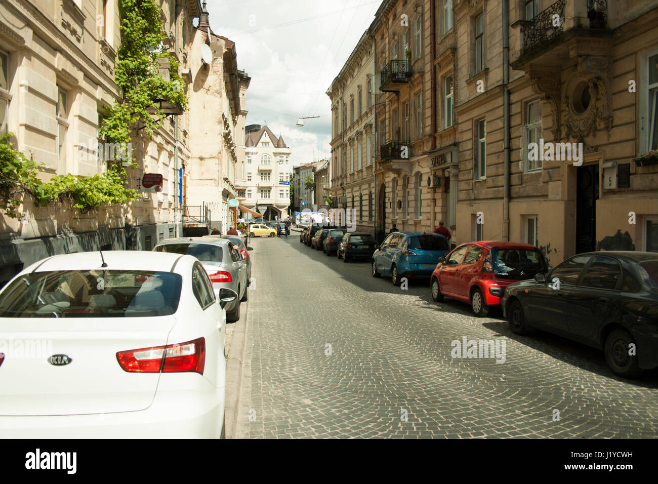 A small street lined with cars Stock Photo - Alamy