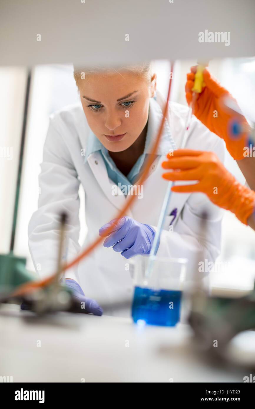 Good looking female take sample of liquid with pipette in lab Stock ...
