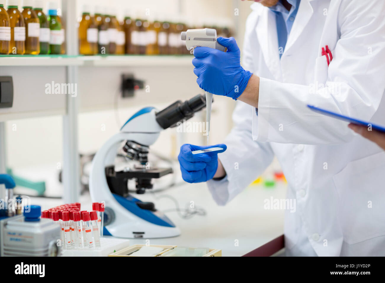 chemical scientist place sample of liquid with sampling pipette on ...