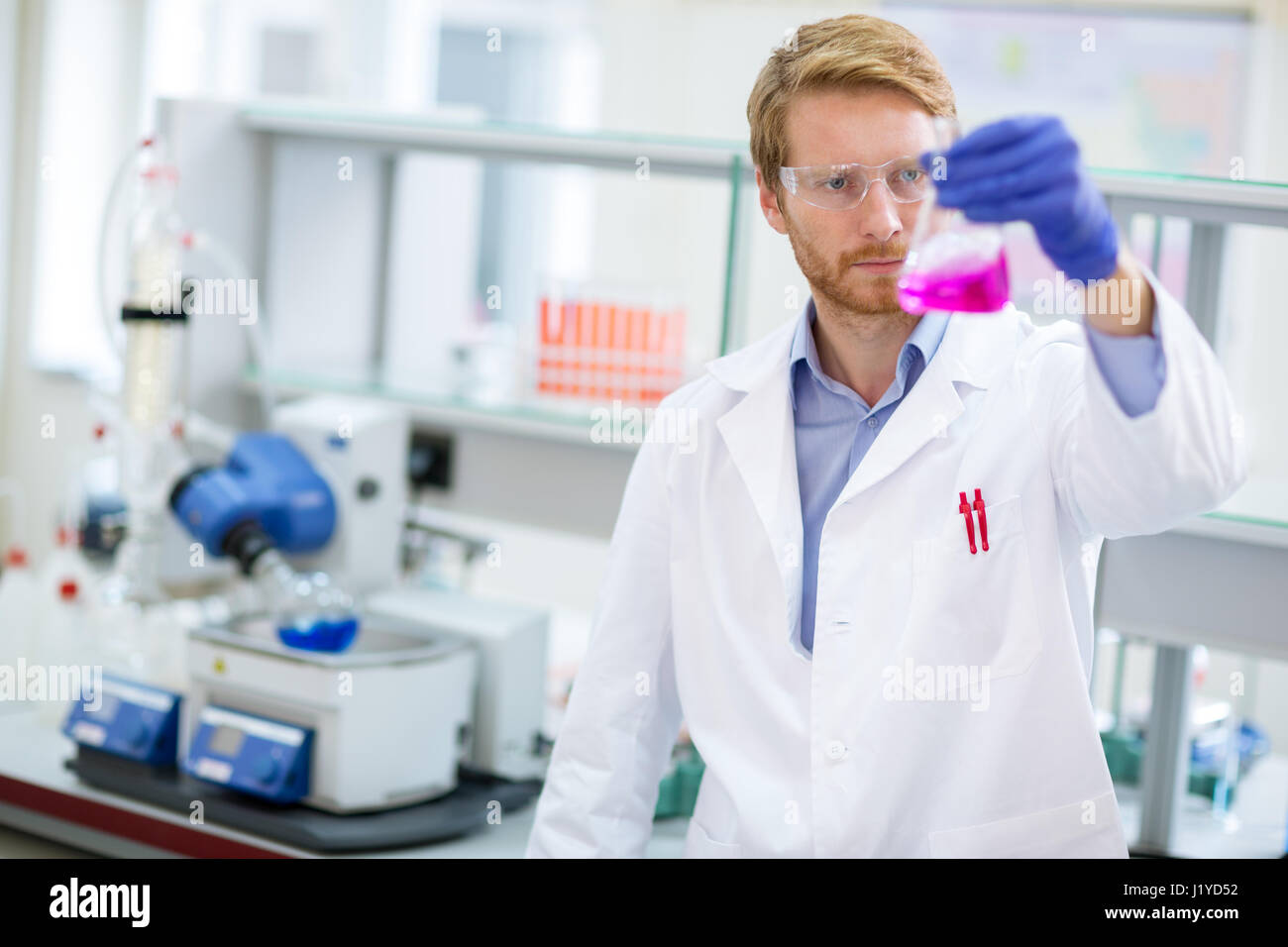 Young chemical technician checking liquid reagent in laboratory Stock ...