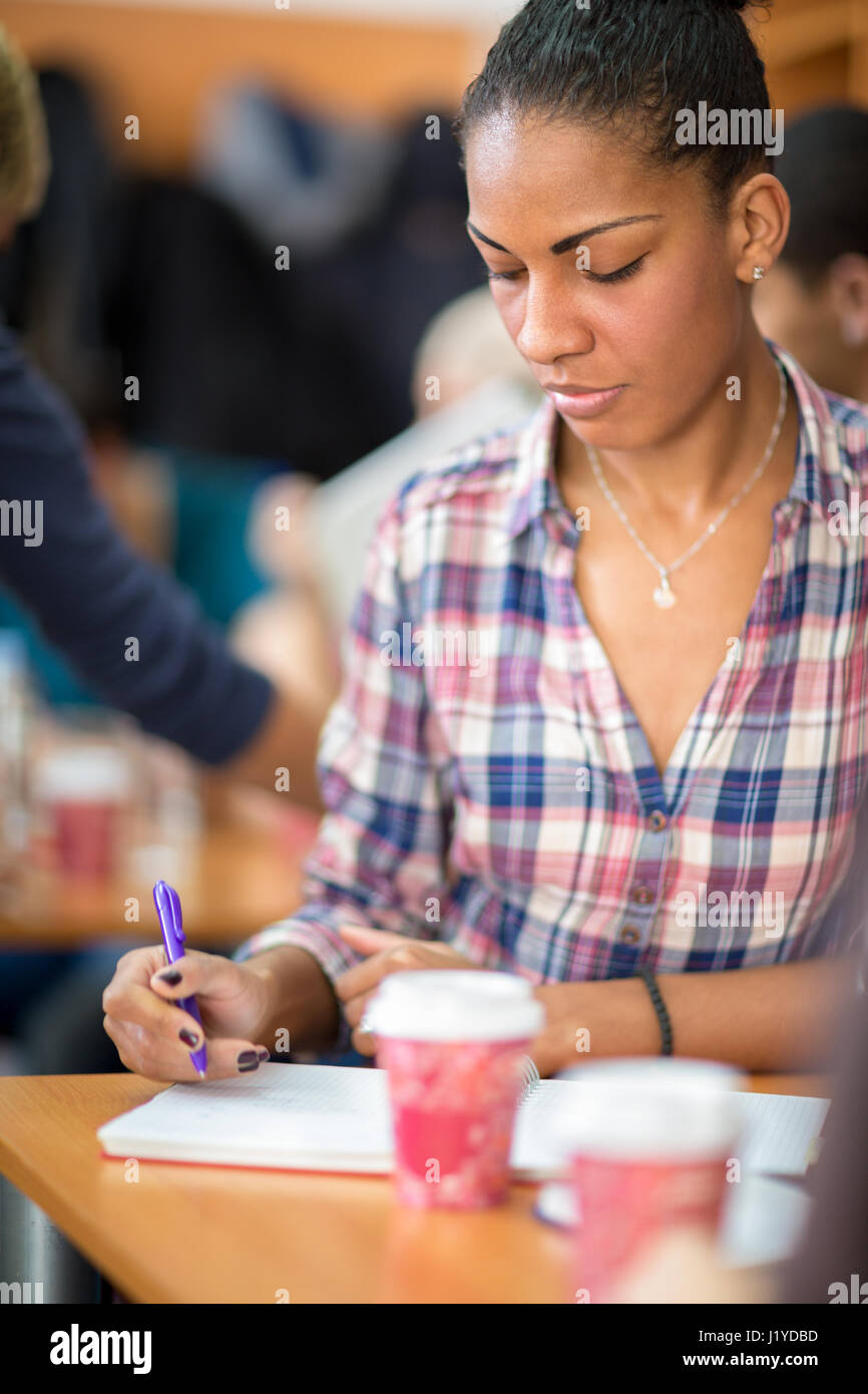 Pretty Afro American student studying and noting on class Stock Photo ...