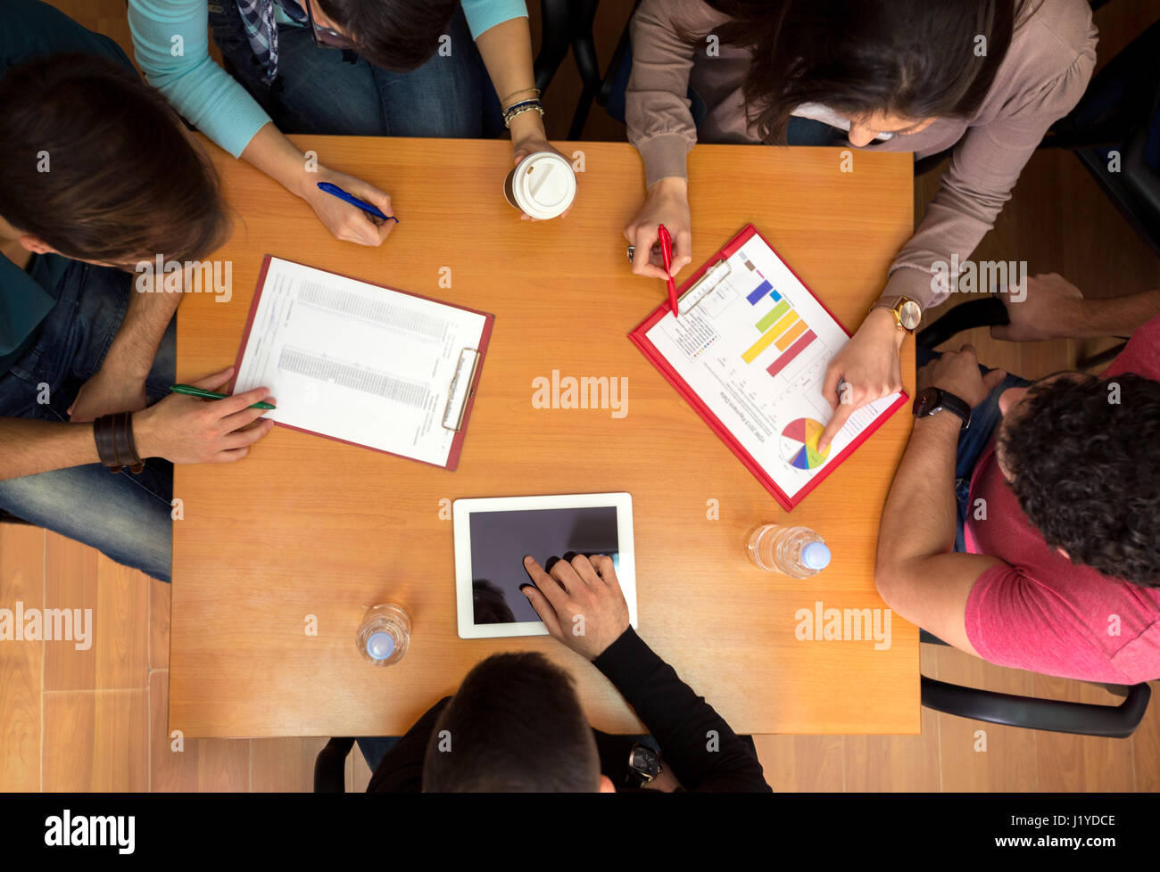 Top view of working table with students, tablet and statistics in ...