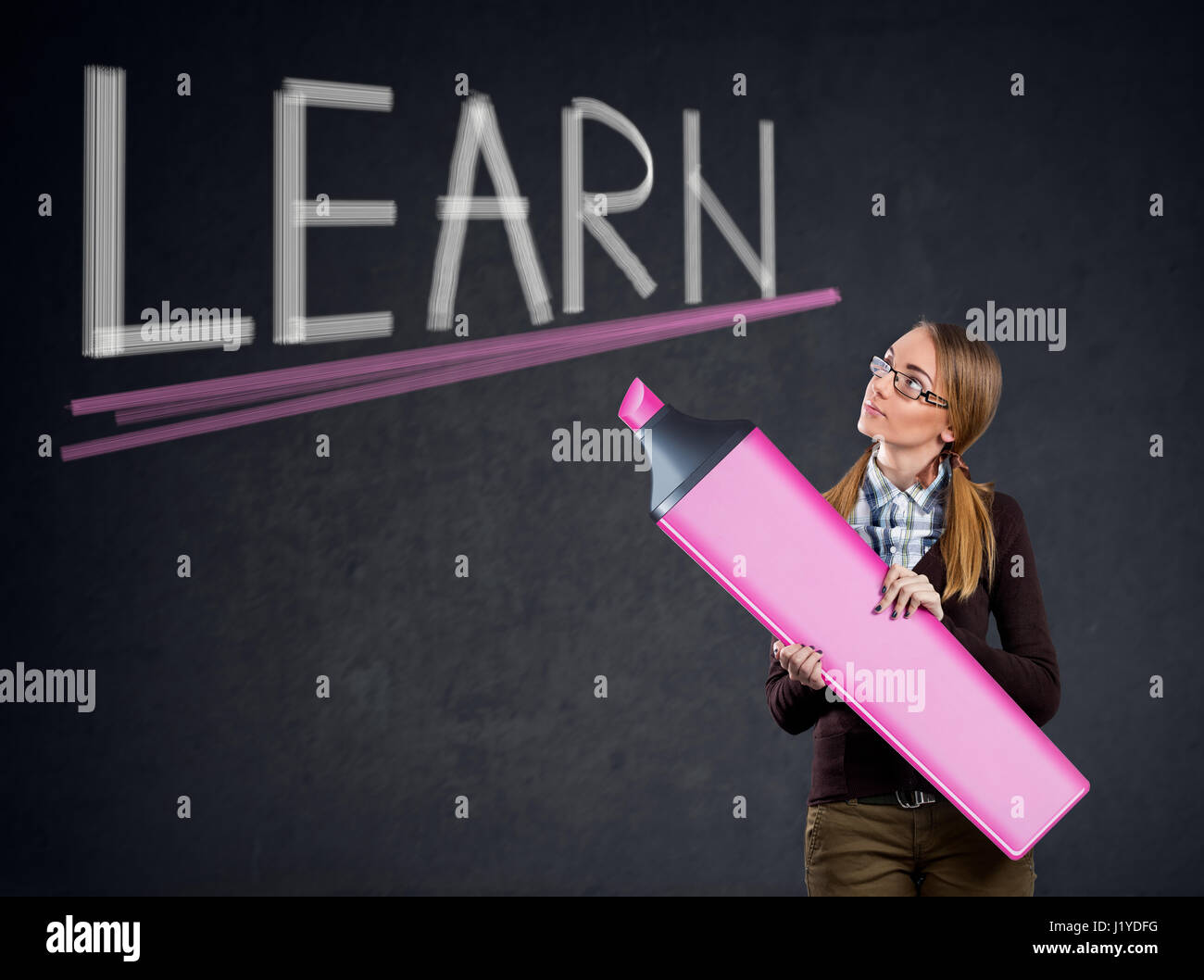 Schoolgirl with big marker writing on the wall word learn Stock Photo ...