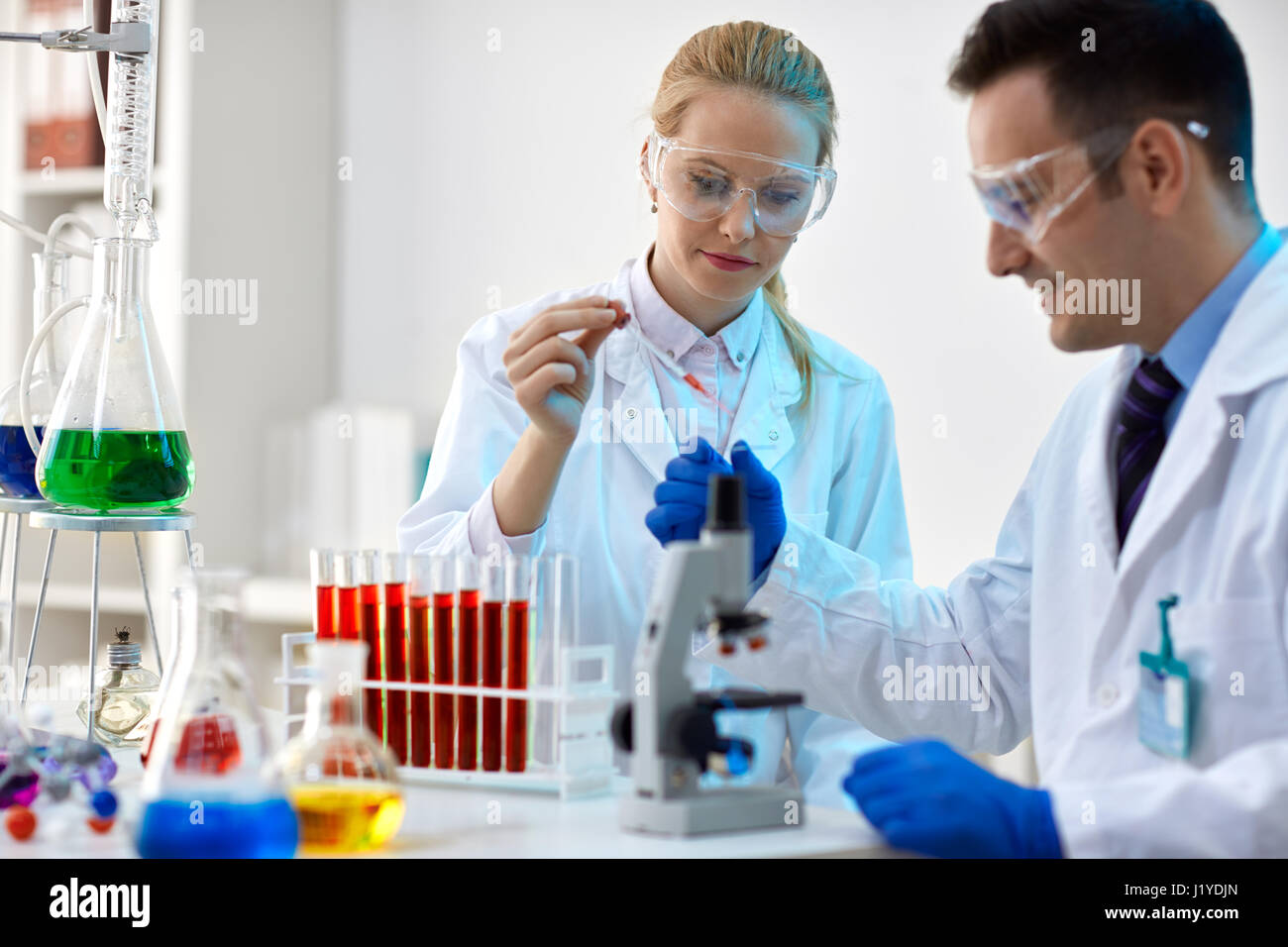 Two young scientists making an experiment in a chemical laboratory ...