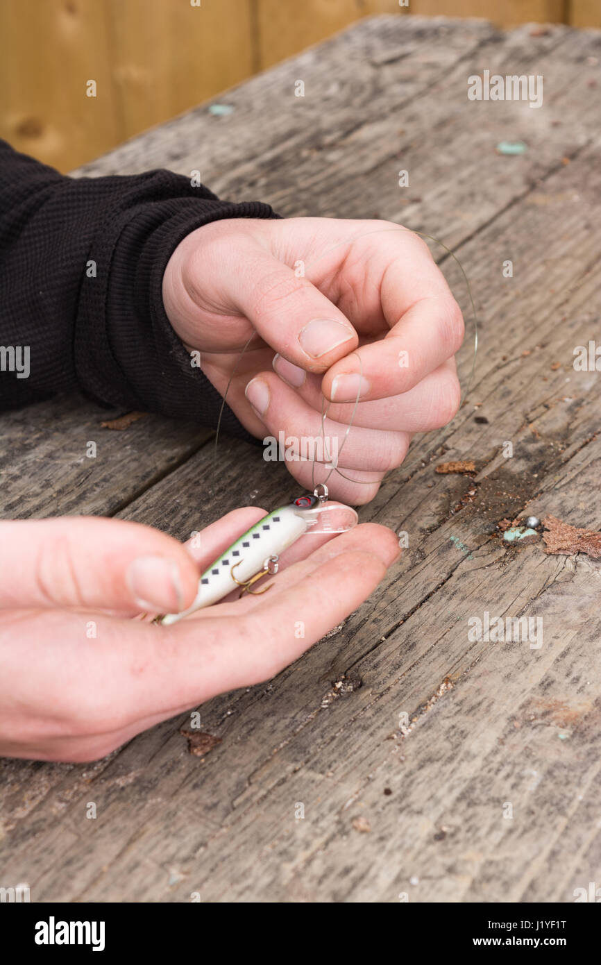 male hands tying a fishing lure to monofilament line Stock Photo - Alamy