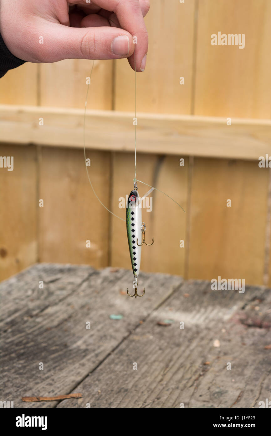 fishing lure freshly tied being held by line Stock Photo - Alamy