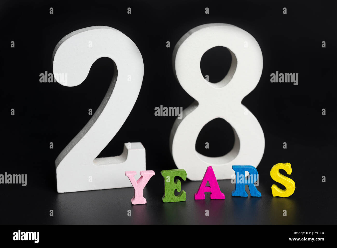 Letters and numbers twenty-eight years on a black isolated background ...