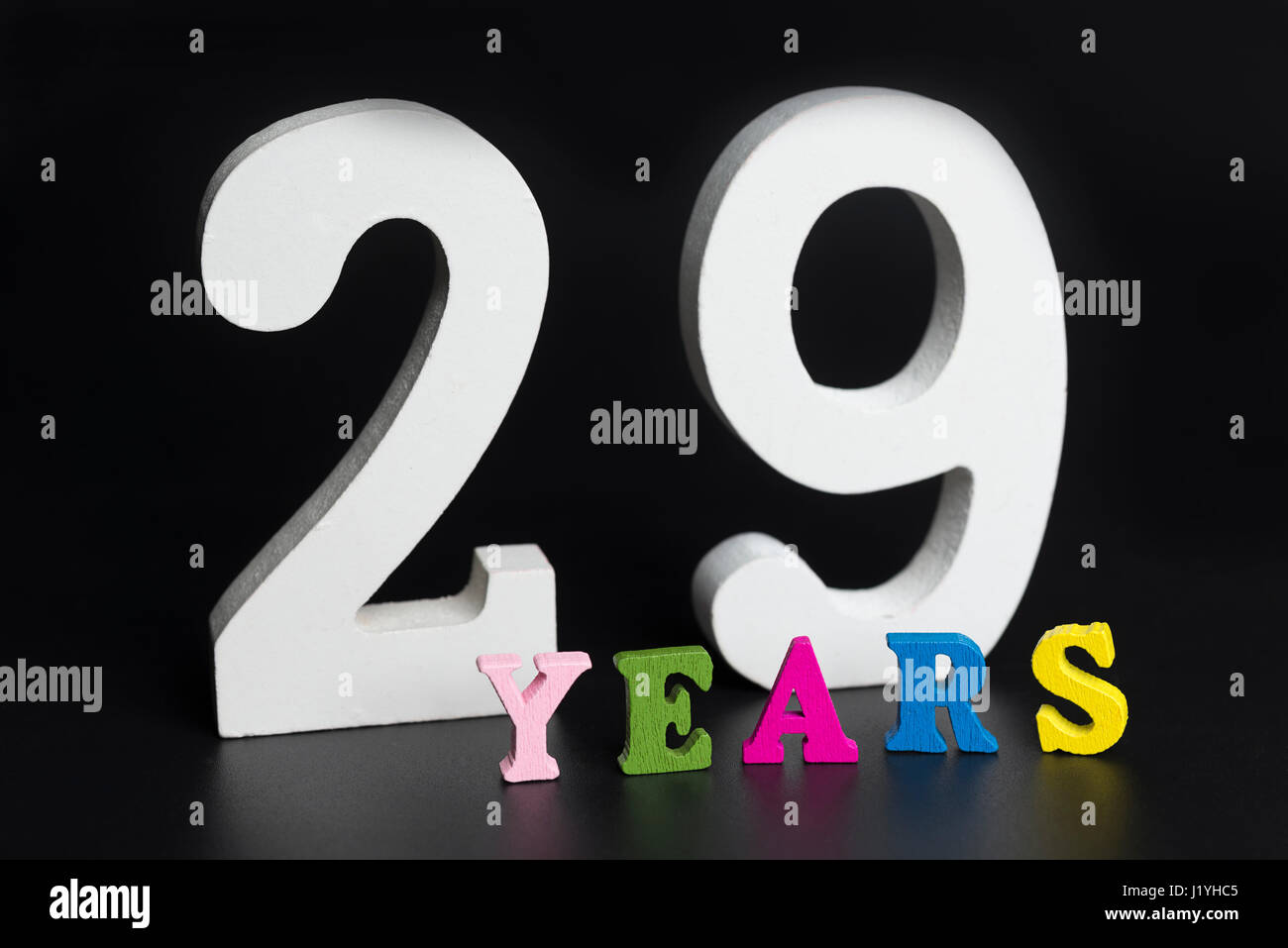 Letters and numbers twenty-nine years on a black isolated background ...
