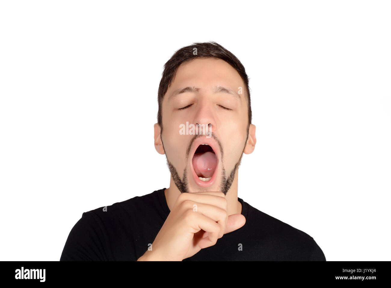Portrait of a young man yawning. Isolated white background Stock Photo ...