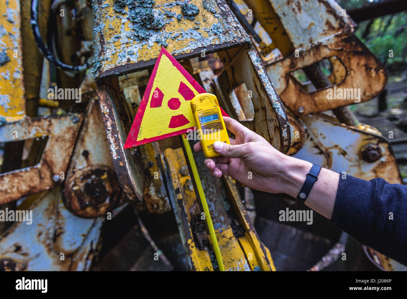 Tourist examine irradiated scrap bucket in Pripyat city of Chernobyl ...