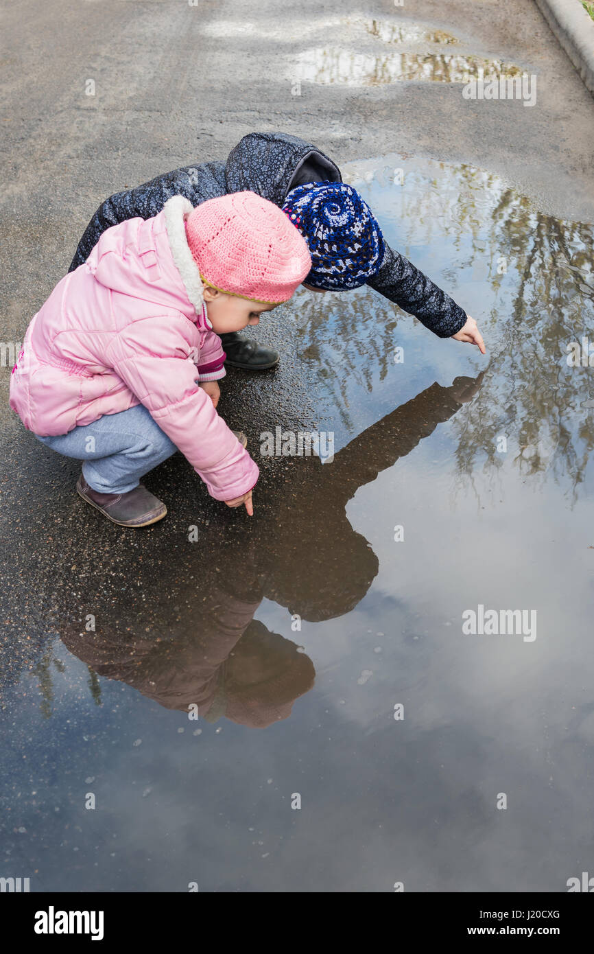 Girls playing in a puddle Stock Photo - Alamy