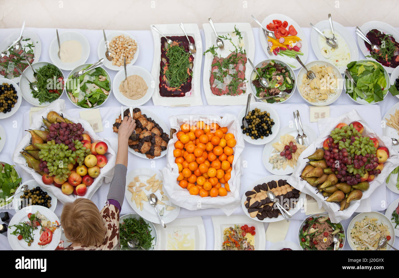 The waiter puts a big dish at the table. the view from the top Stock ...