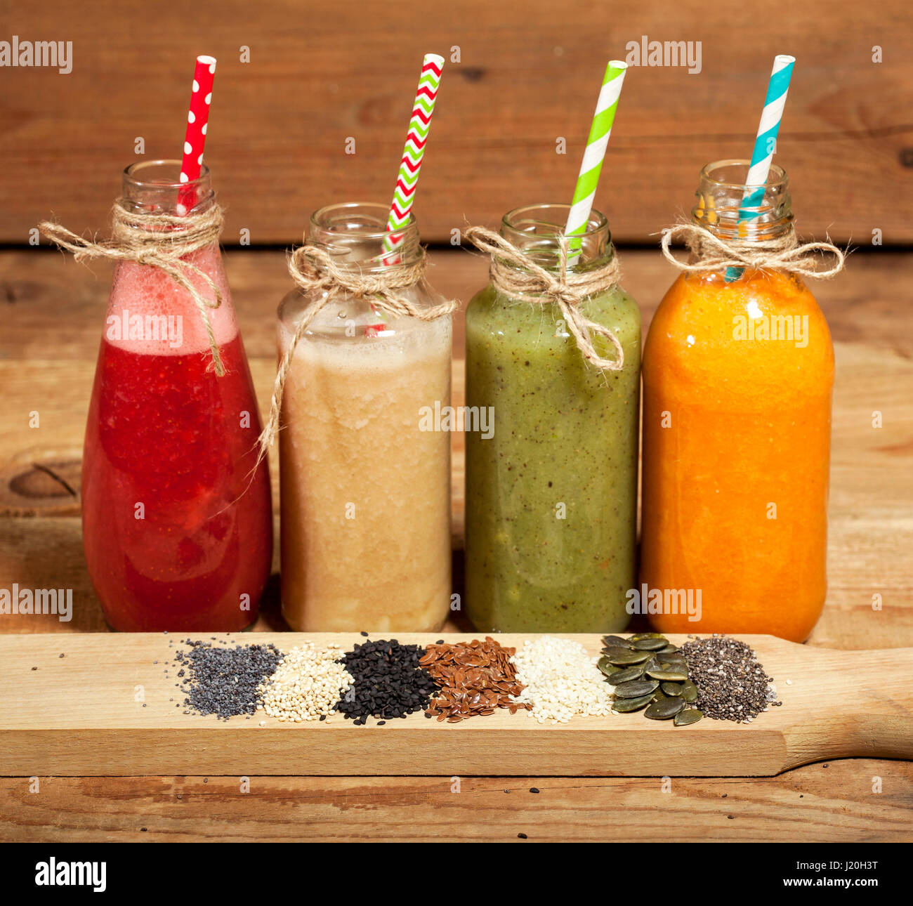 Assortment of fruit and vegetable smoothies in glass bottles with ...