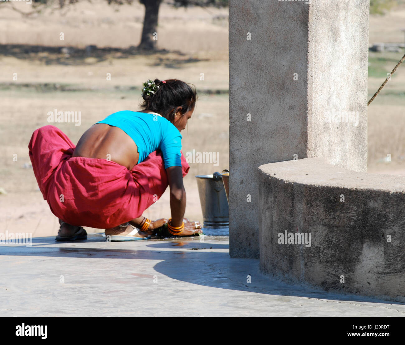 Woman washing by a well Stock Photo - Alamy